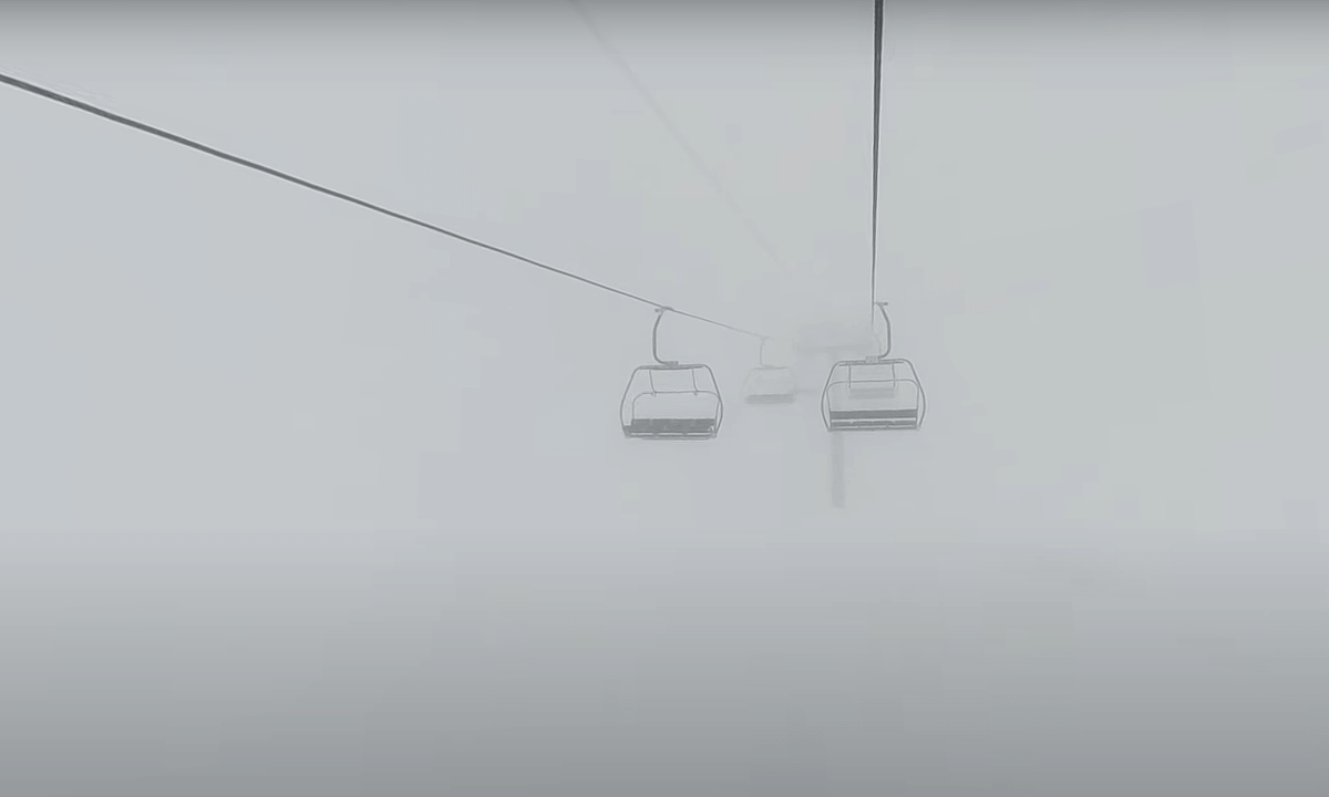 On the chairlift in a white-out, surrounded by an heavy fog _ A winter ...